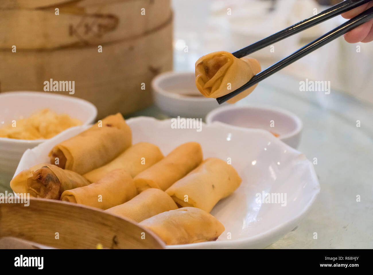 Fried spring rolls are grab by chopsticks black Stock Photo - Alamy