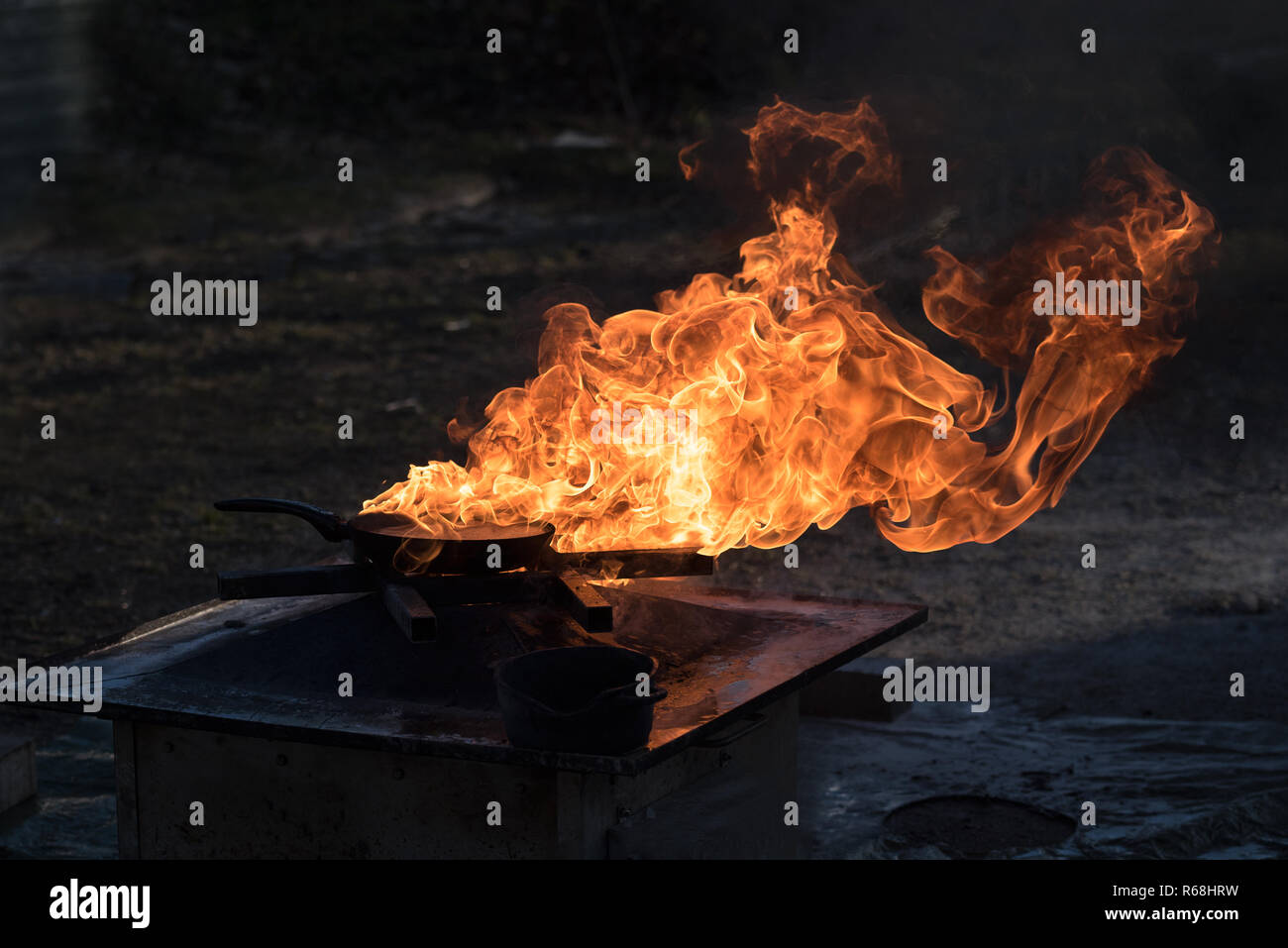 fire on an iron pan, extinguishing demonstration during a fire ...