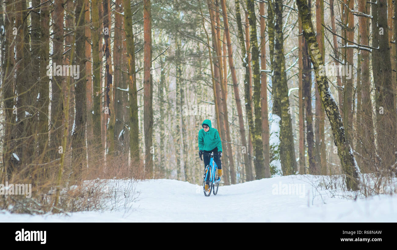 Cyclist on cyclocross bike trails in the snowy forest in winter. Winter ...