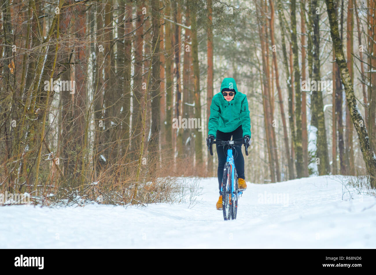 Cyclist on cyclocross bike trails in the snowy forest in winter. Winter ...