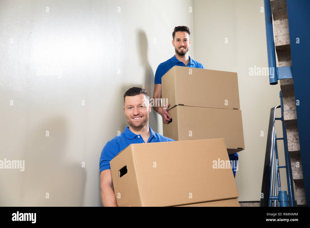 Two Movers Carrying Cardboard Boxes On Staircase Stock Photo - Alamy