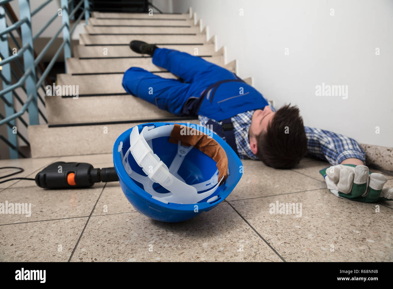 Handyman Lying On Staircase Stock Photo - Alamy