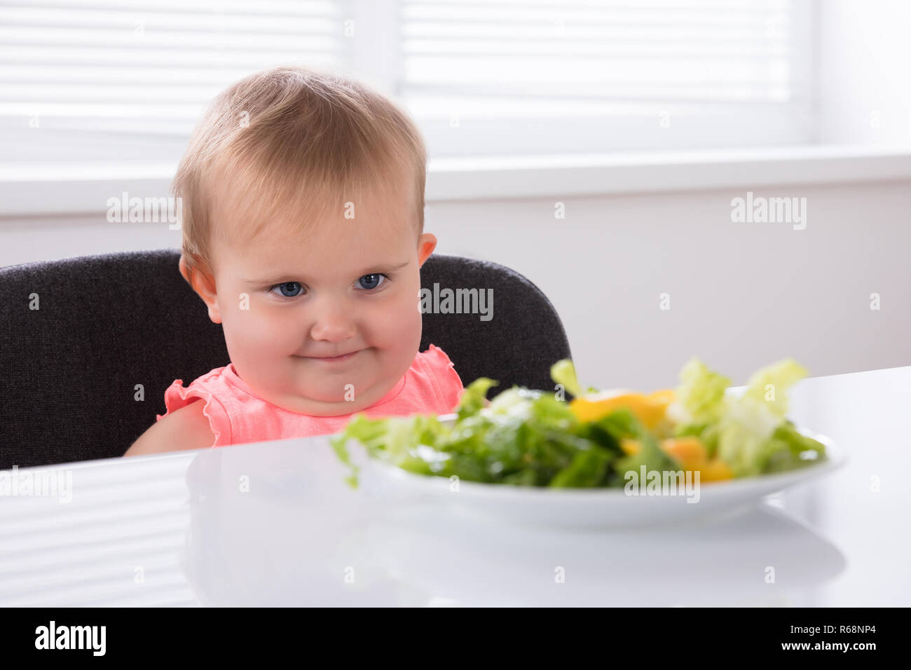 Cute Baby Looking At Food In Plate Stock Photo - Alamy