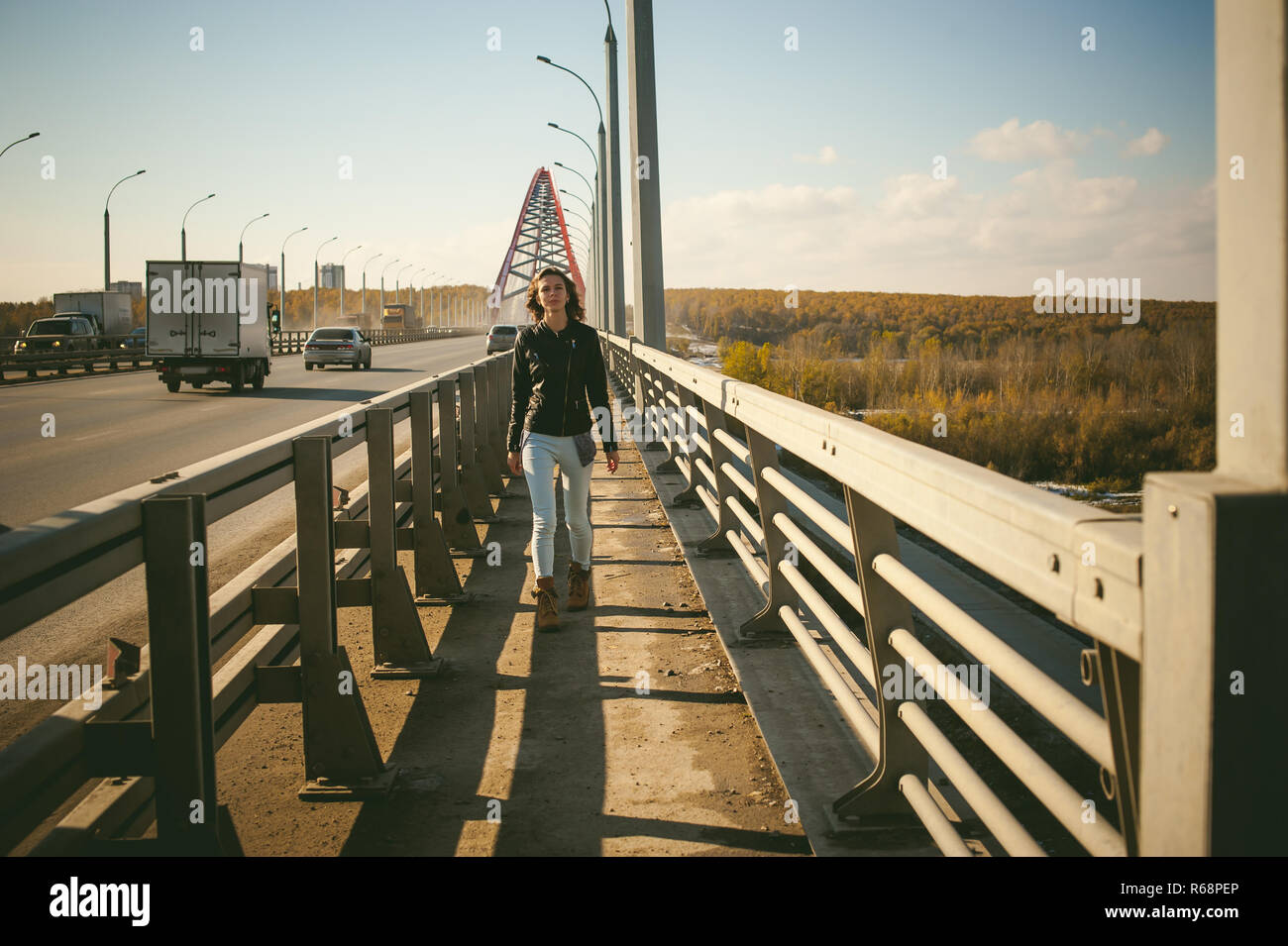 girl goes on road bridge. lonely young woman in black Leather jacket ...