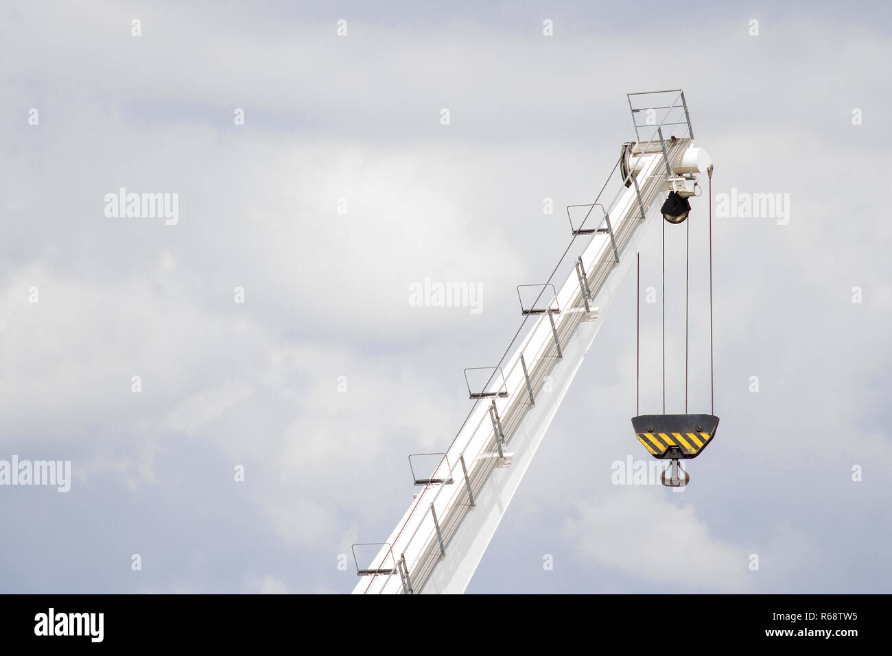 White lifting crane with black lifting hoop Stock Photo - Alamy