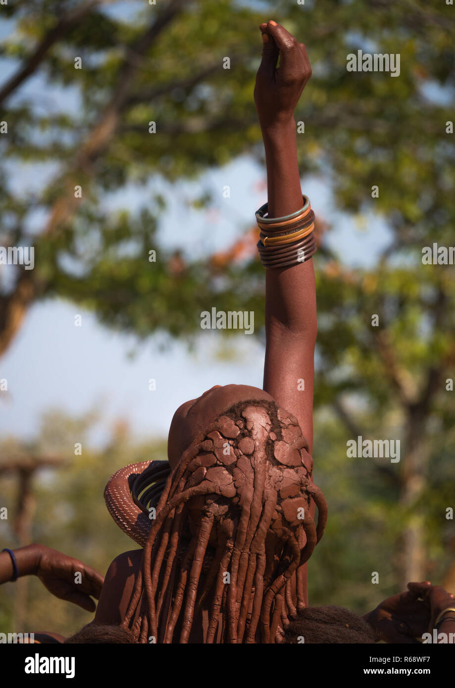 Himba tribe young woman looking at a drone in the sky, Cunene Province ...