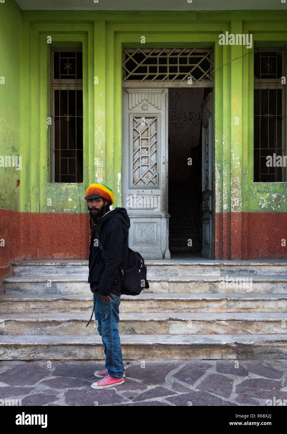 Rastafarian man standing in front of an old portuguese colonial ...