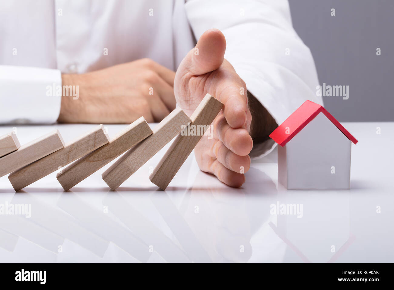 Human Hand Stopping The Wooden Blocks From Falling Stock Photo - Alamy