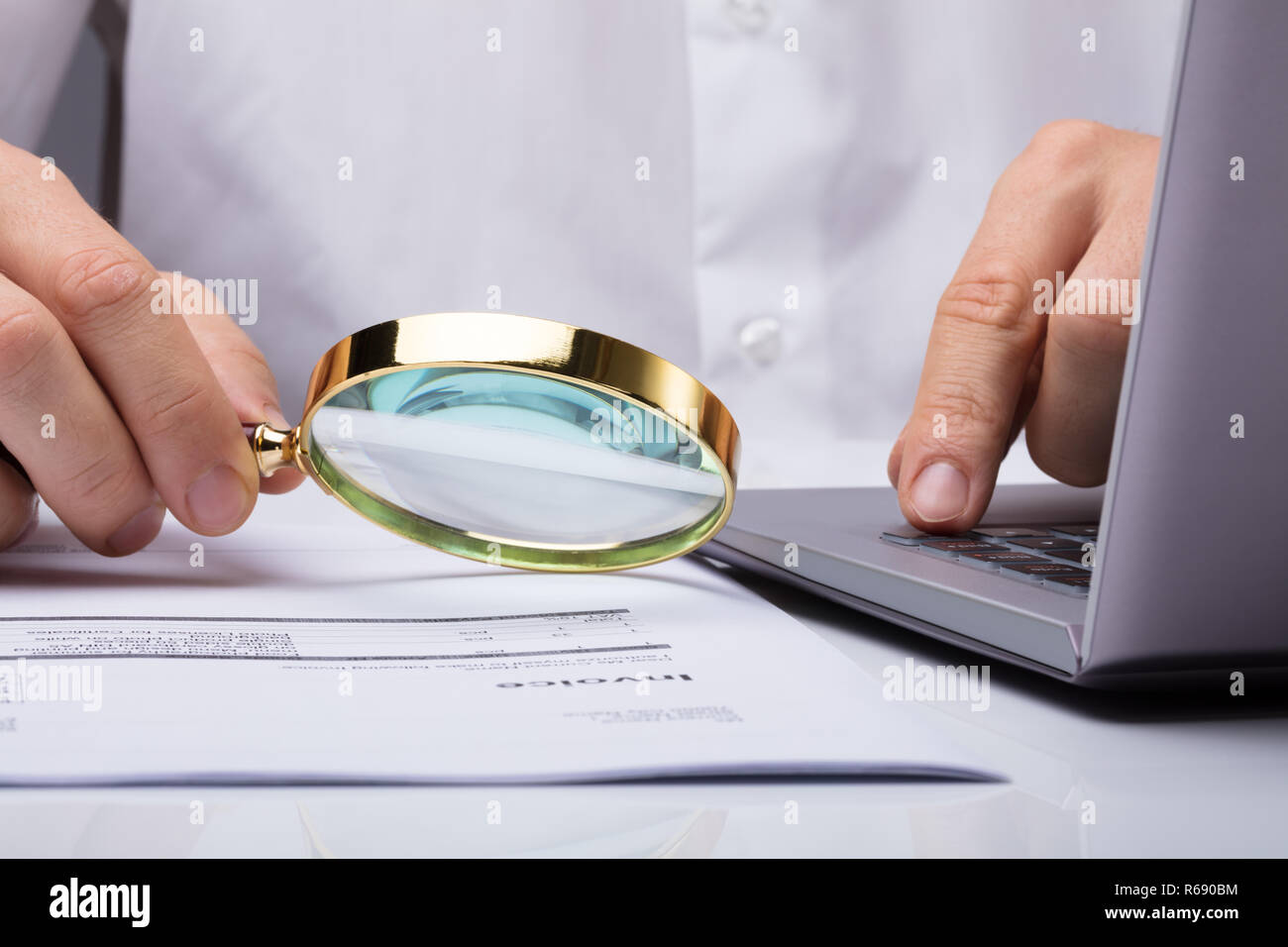 Businessman Examining Invoice With Magnifying Glass Stock Photo - Alamy