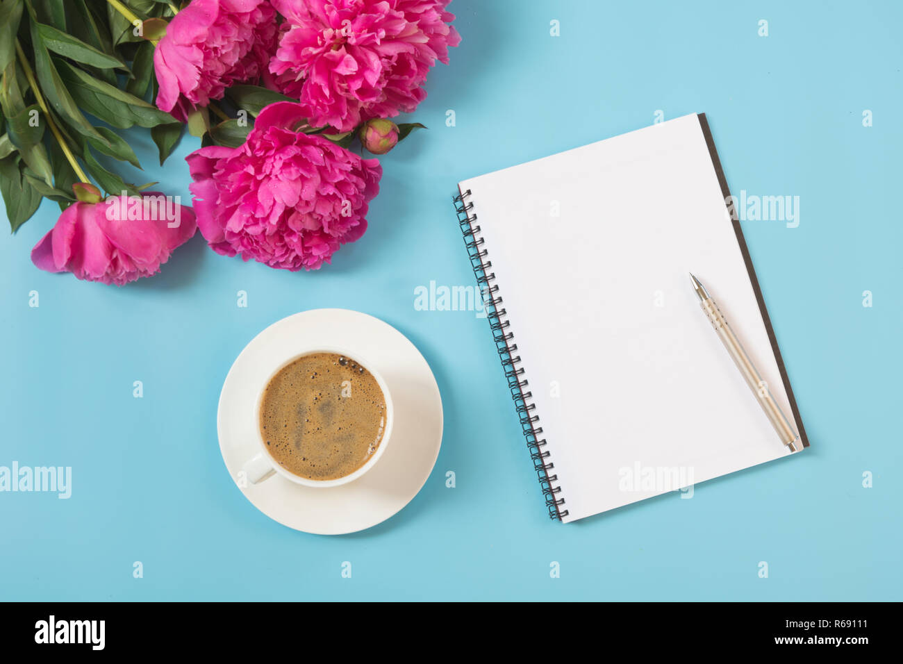 Bouquet of pink peony flower and white copybook with pen on punchy ...