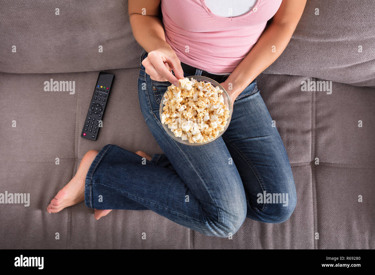 Woman Sitting On Sofa Eating Popcorn Stock Photo - Alamy