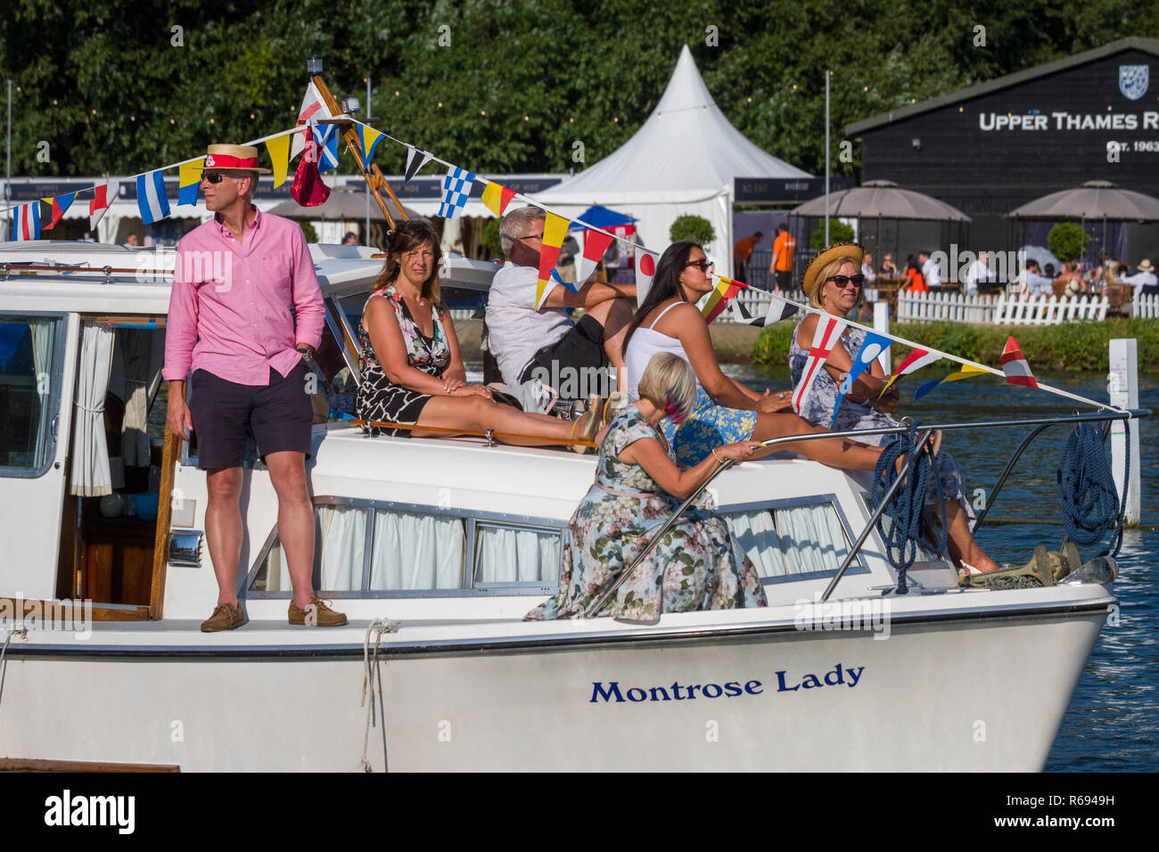 A family group on a cabin cruiser pass the Upper Thames rowing Club at ...