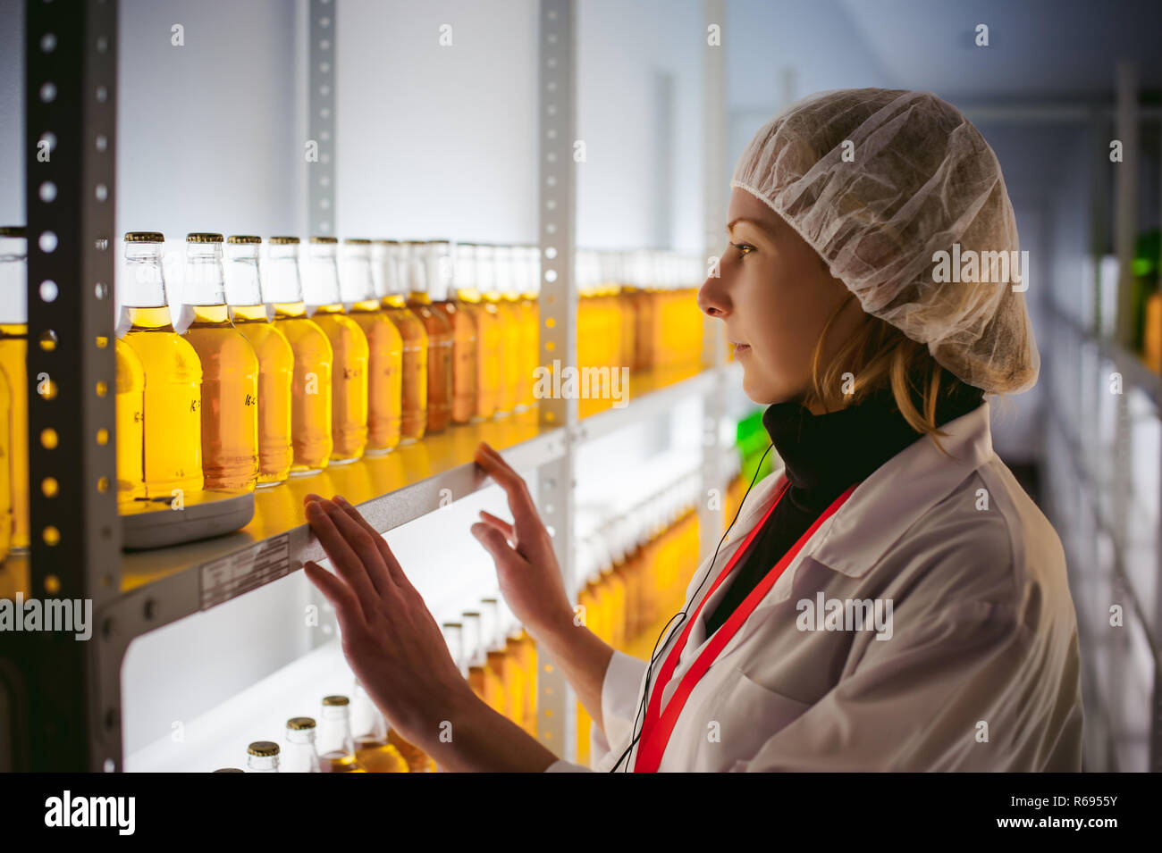 employee of beer production laboratory. Young lab assistant, dressed in ...