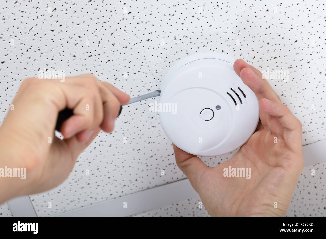Person's Hand Using Screwdriver To Install Smoke Detector Stock Photo ...