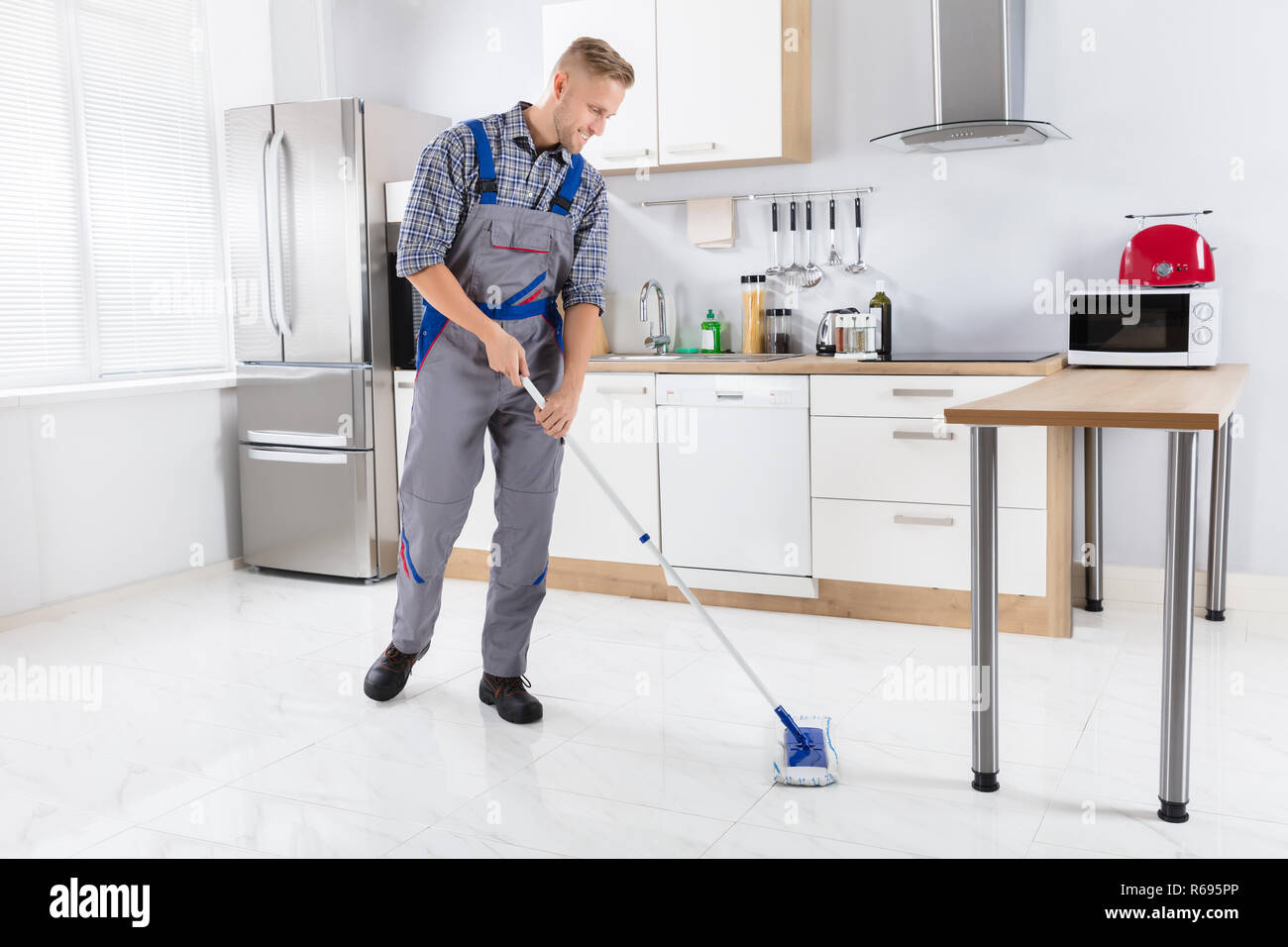 Young Male Worker Mopping Floor Stock Photo - Alamy