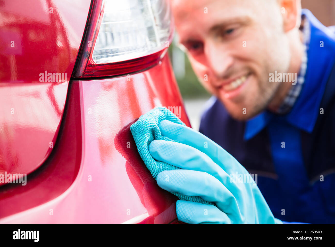Happy Male Worker Cleaning Red Car Stock Photo - Alamy