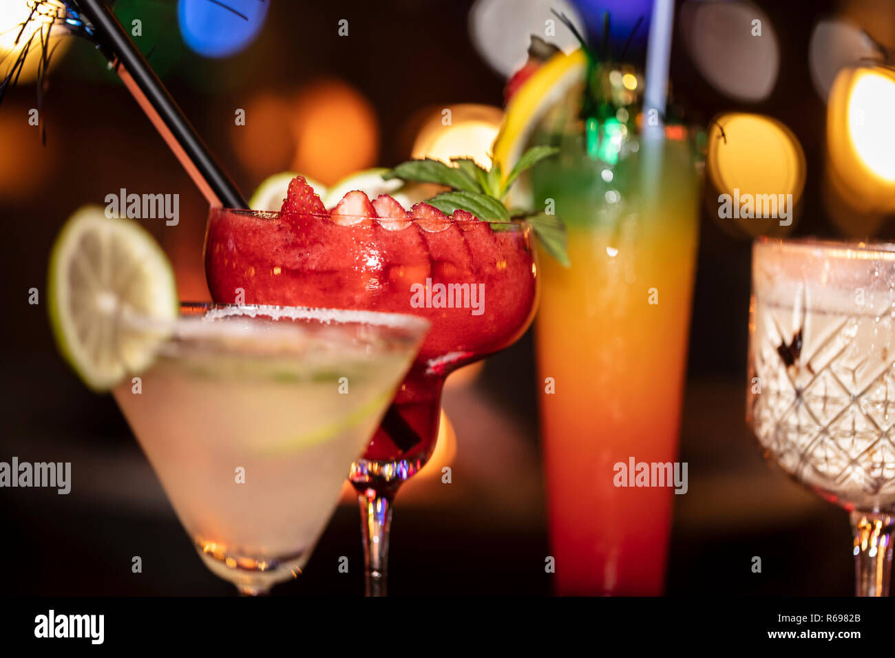 Alcoholic cocktail row on bar table, colorful party drinks Stock Photo ...