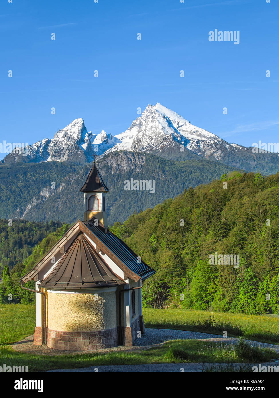 Vertical view of small chapel and snowy summit of Watzmann mountain ...