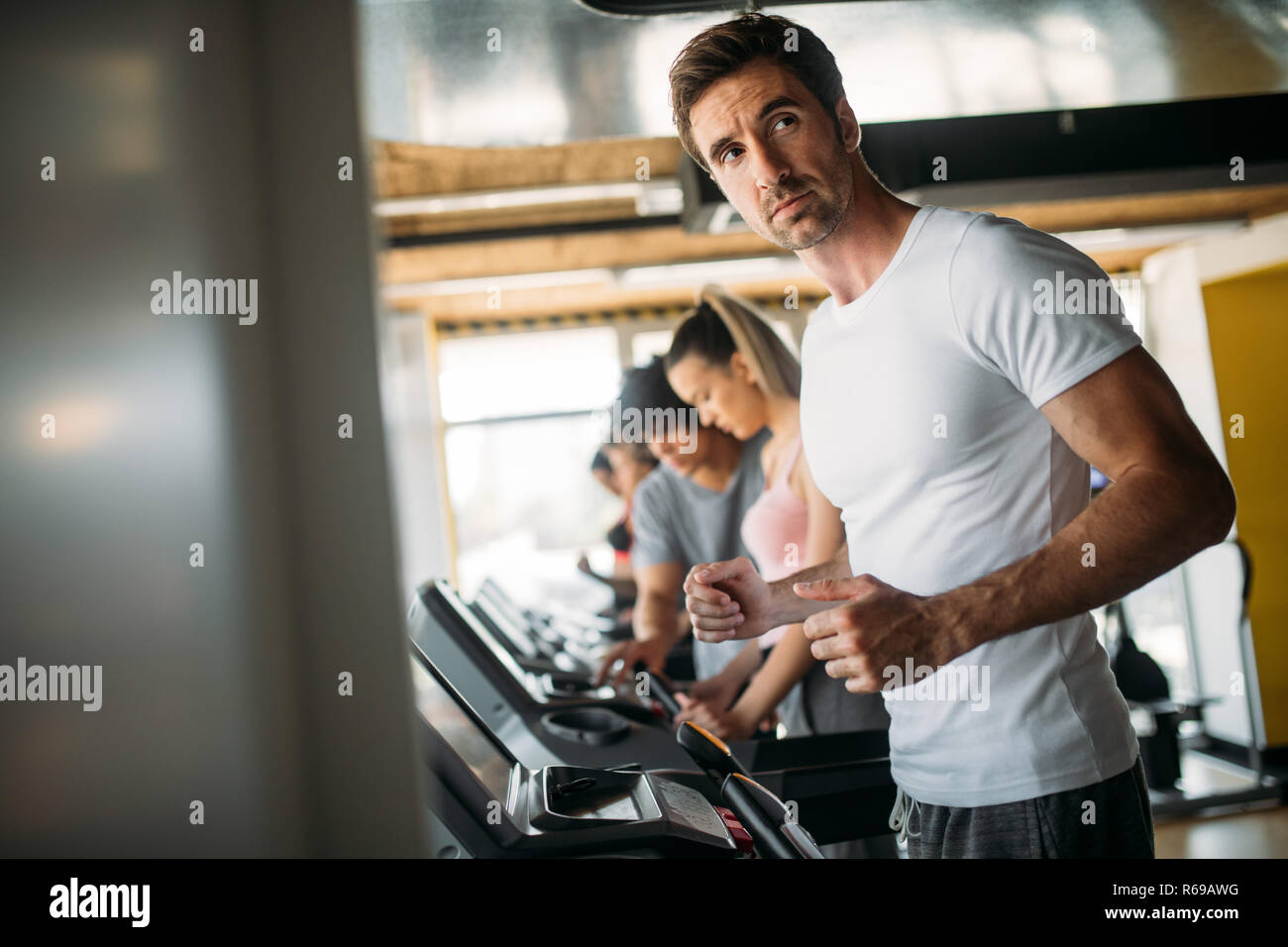 Group of young people running on treadmill in gym Stock Photo - Alamy