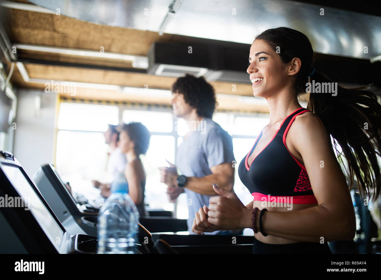 Group of young people running on treadmill in gym Stock Photo - Alamy