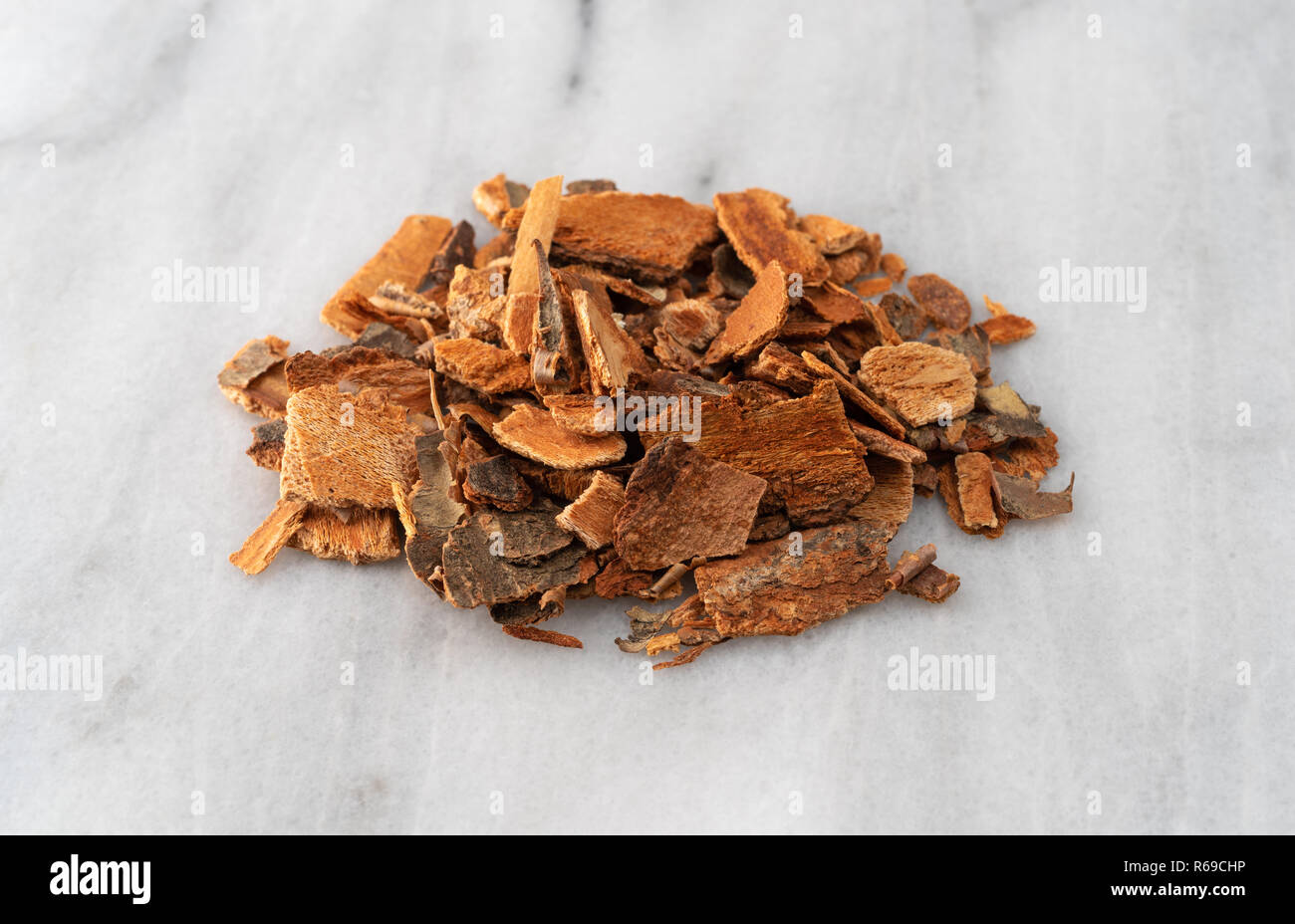 Small pile of wild cut cherry tree bark on a gray marble counter top ...