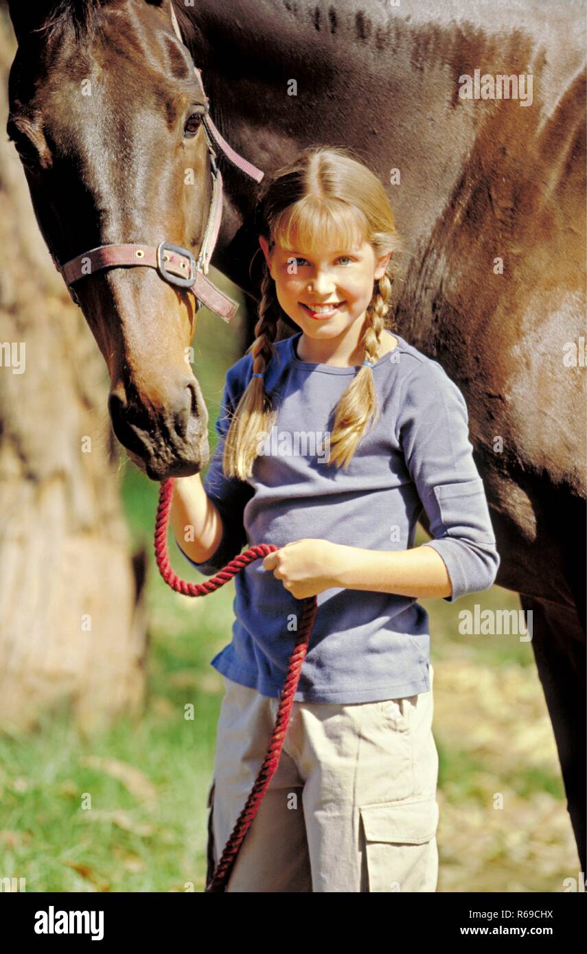 Portrait, Maedchen, 12 Jahre, mit langen blonden Zoepfen mit ihrem ...
