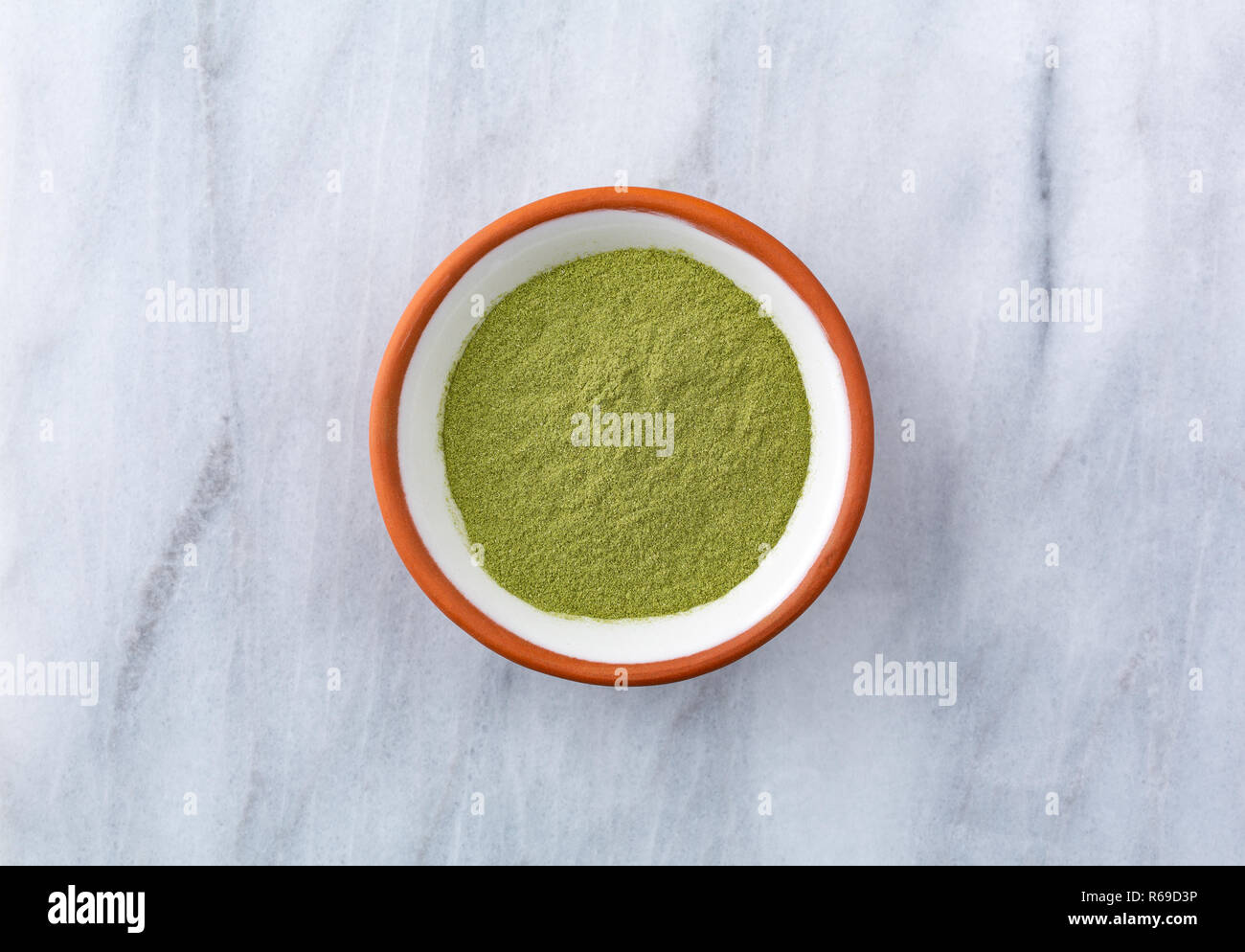 Top view of a portion of organic powdered wheat grass in a small bowl ...