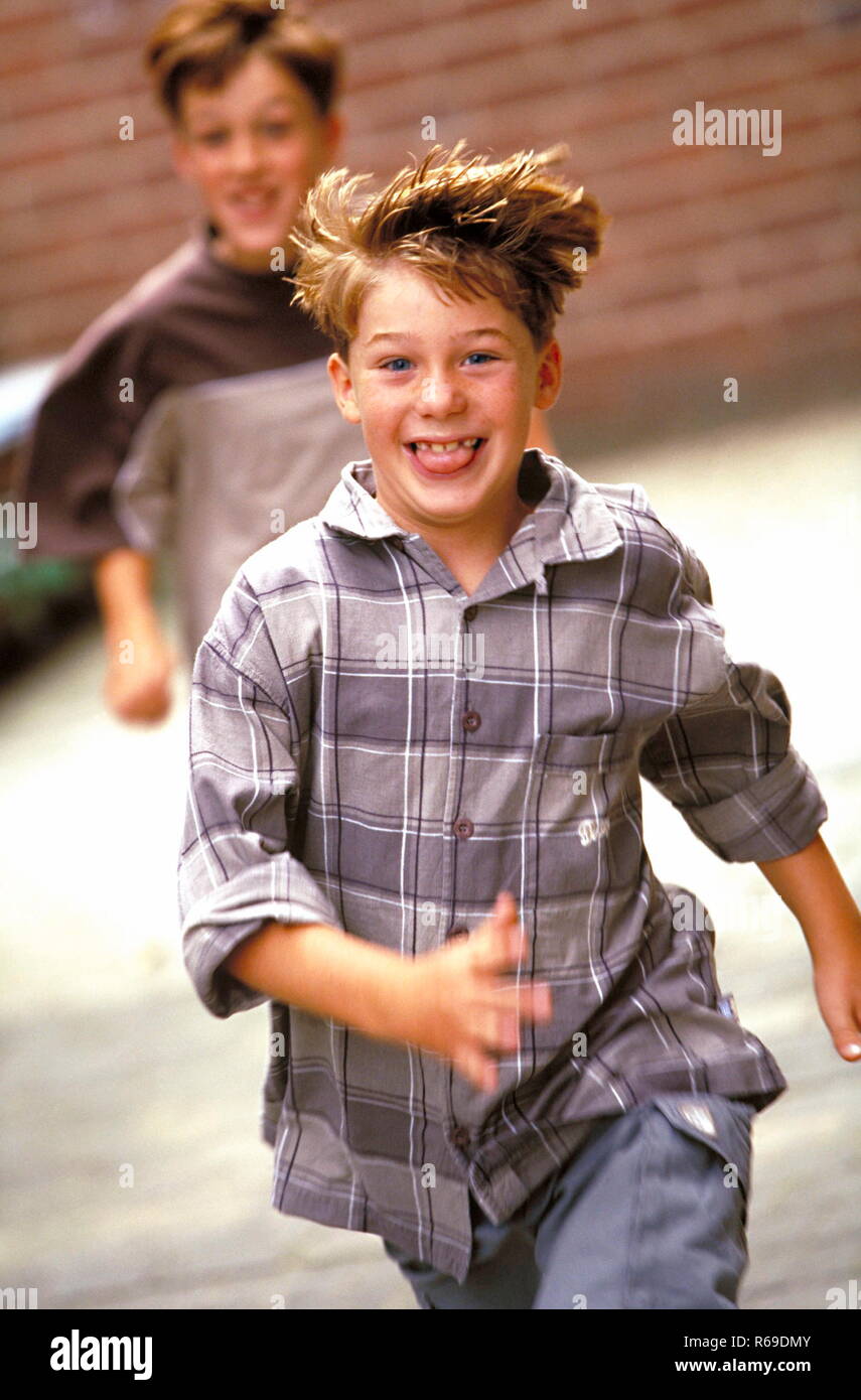 Outdoor, 2 Jungen 10-12 Jahre spielen nachlaufen Stock Photo - Alamy