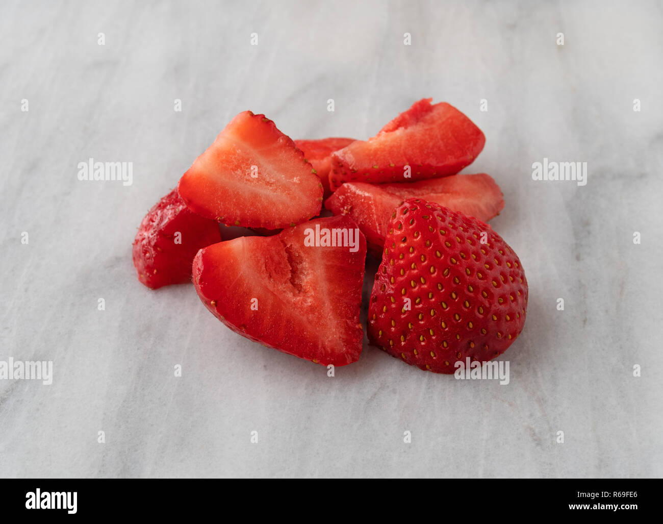 A serving of freshly cut strawberries on a marble counter top Stock ...