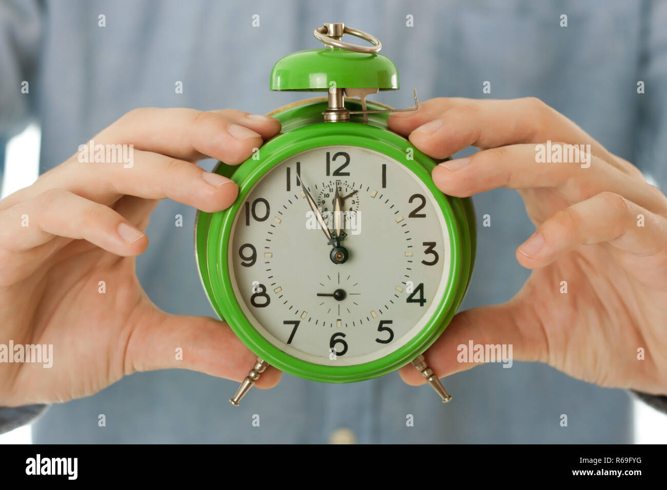 Man holding clock and showing time Stock Photo - Alamy