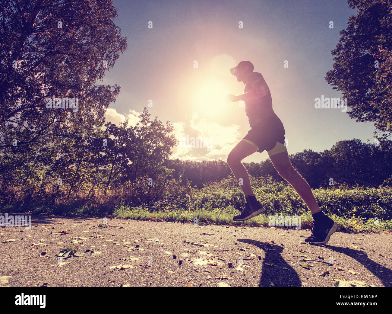 The man run in the forest. The Athletic man running on a forest trail ...