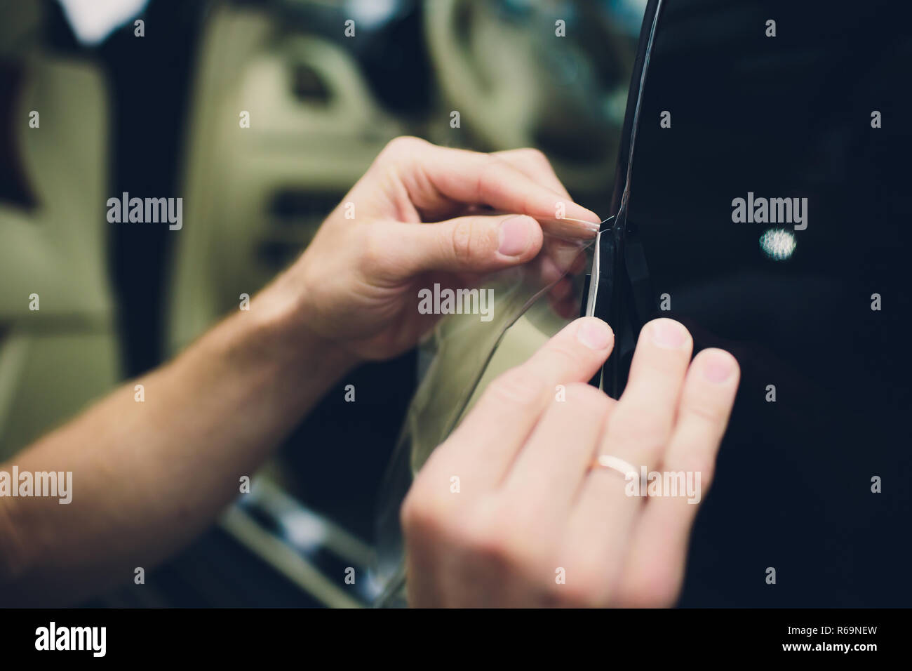 Worker hands installs car paint protection film Stock Photo - Alamy