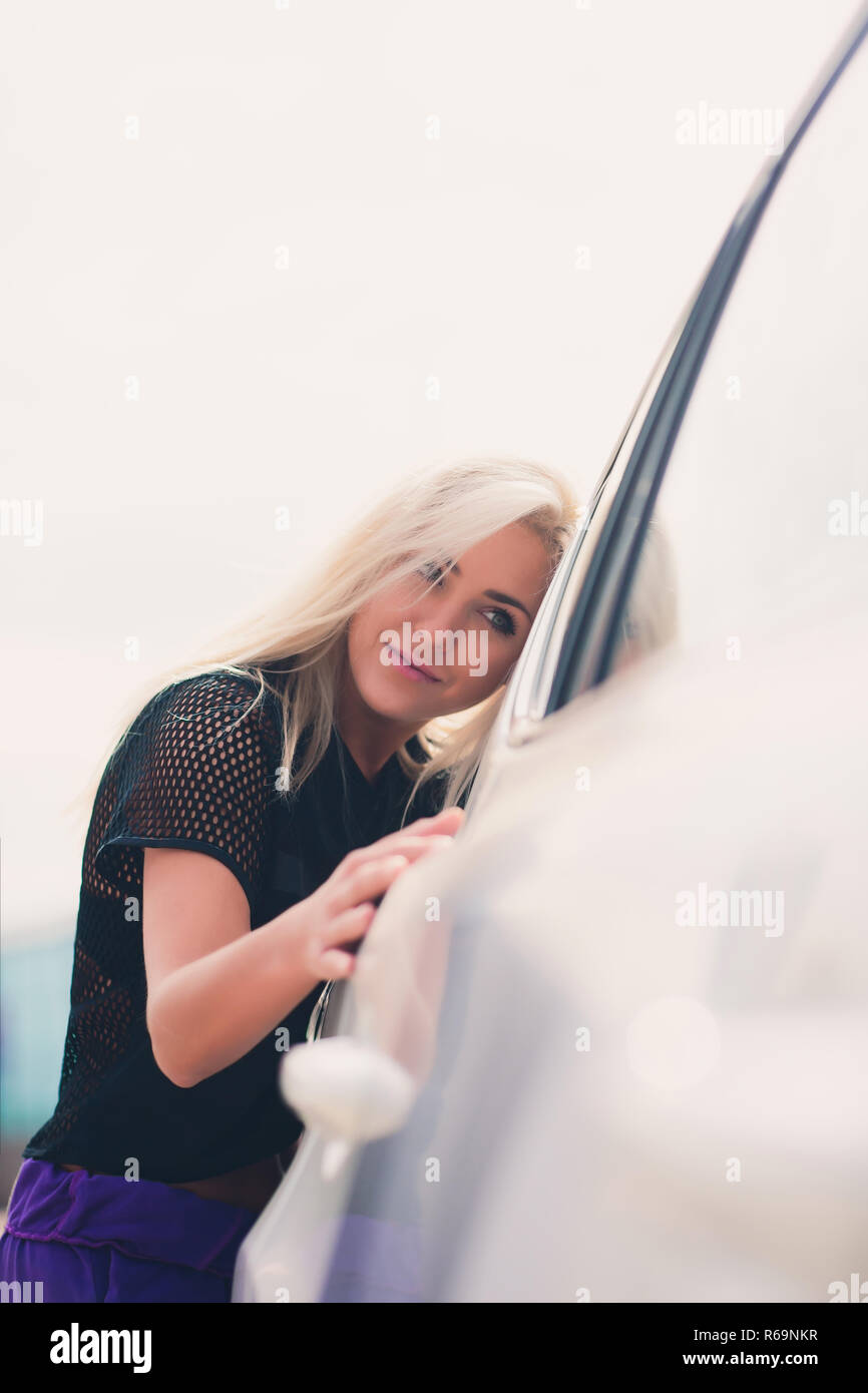 Cheerful young female driver hugging her new car Stock Photo - Alamy