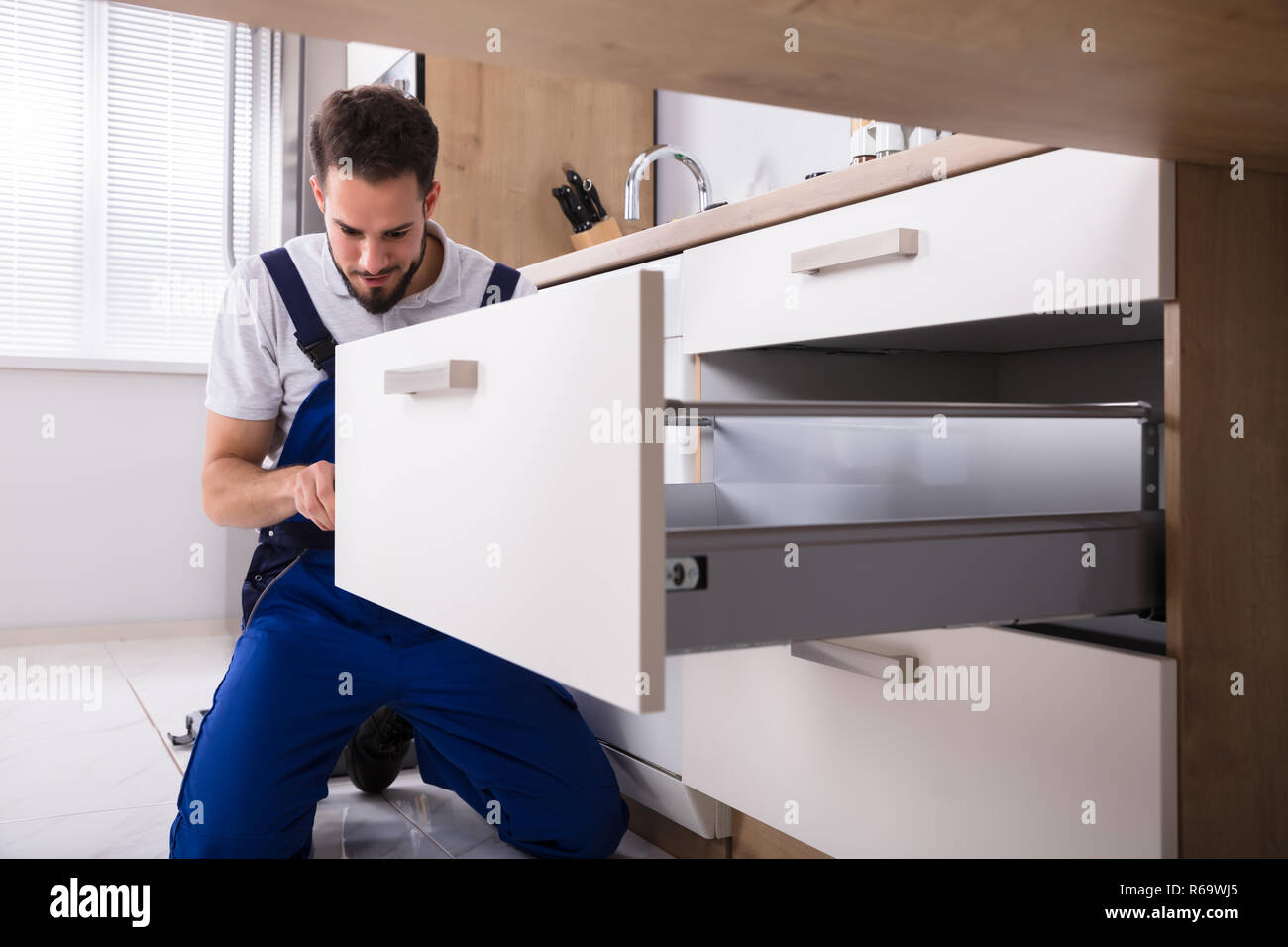 Handyman Installing Drawer Stock Photo - Alamy