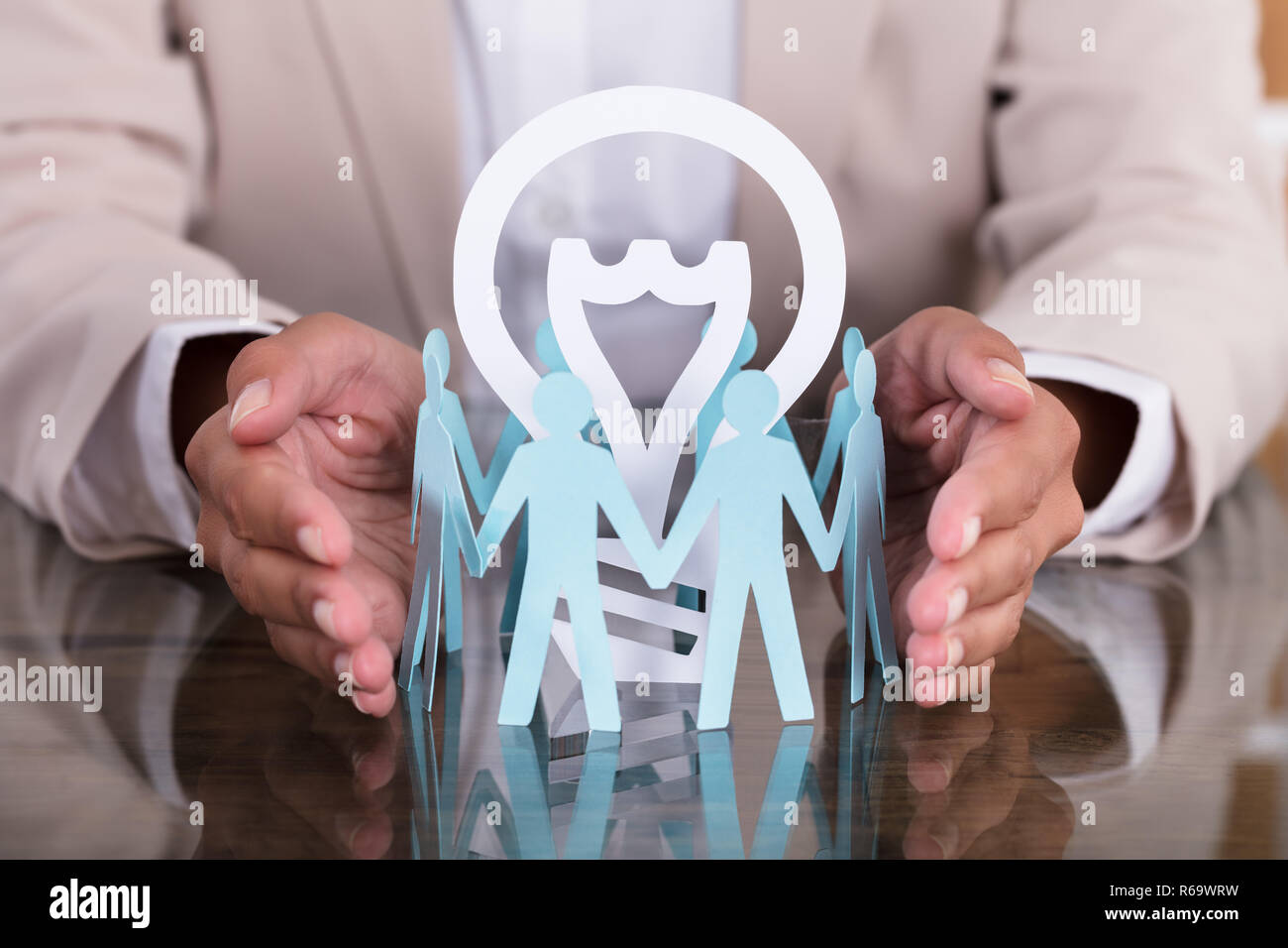 Hand Protecting Light Bulb Surrounded By Human Figures Stock Photo - Alamy