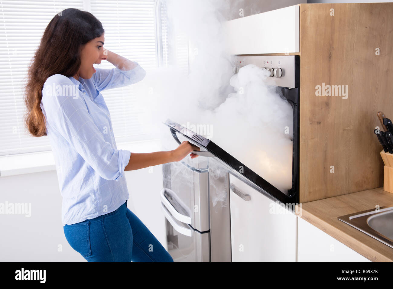 Shocked Woman Looking At Smoke Coming From Oven Stock Photo - Alamy