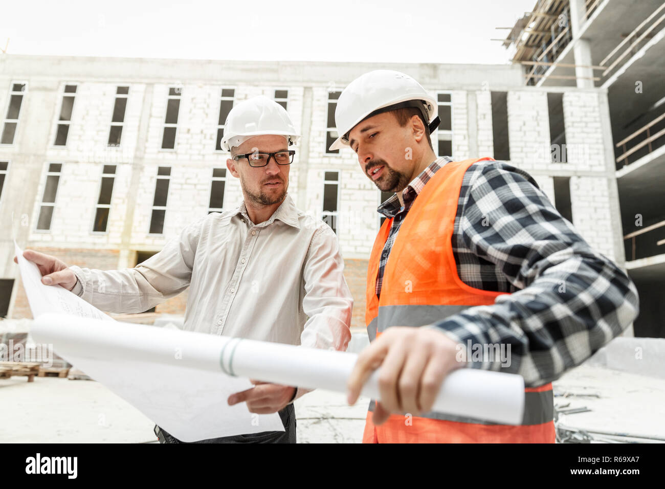 Male architect and developer with blueprints discussing architect ...