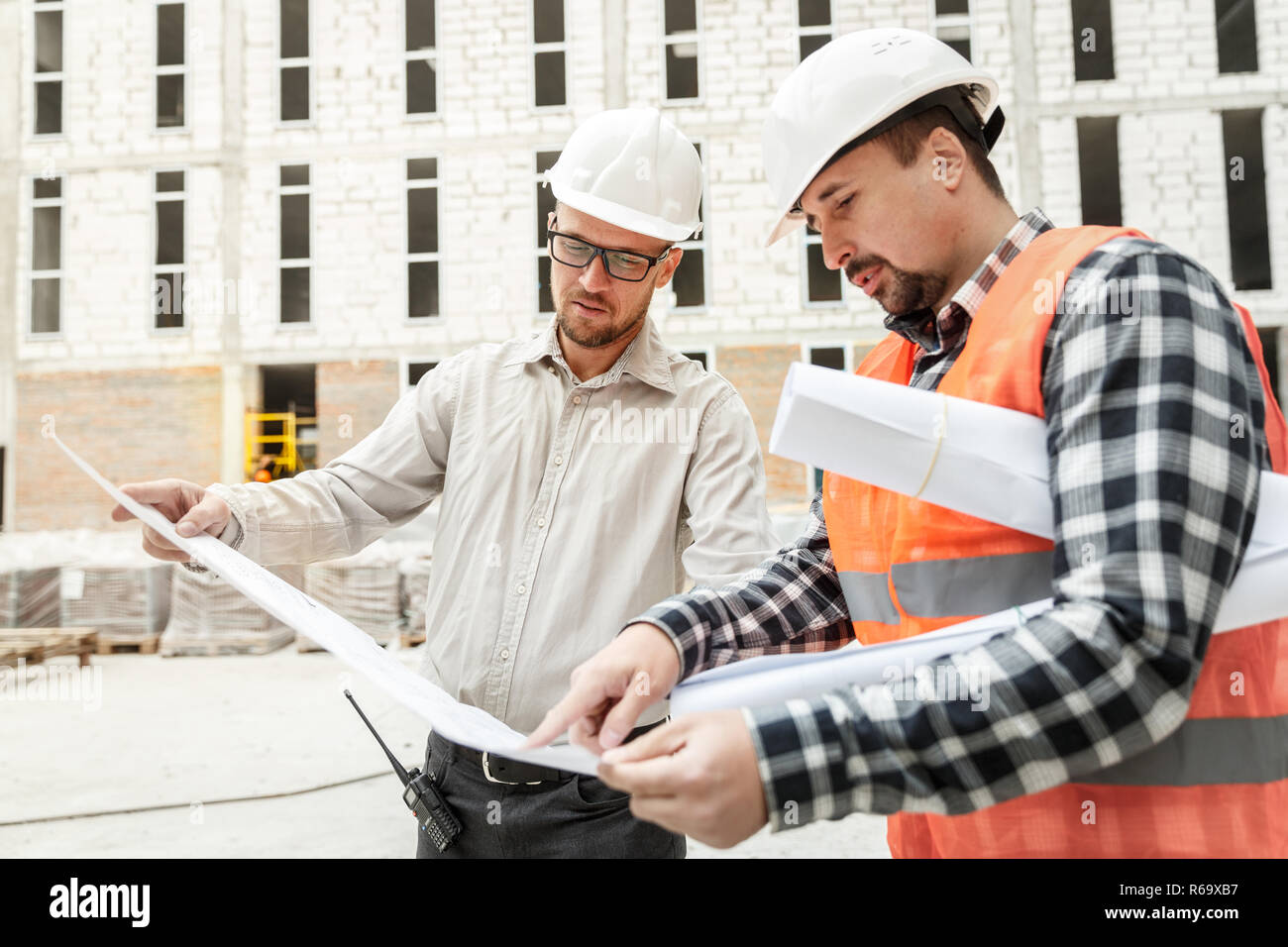 Male architect and developer with blueprints discussing architect ...