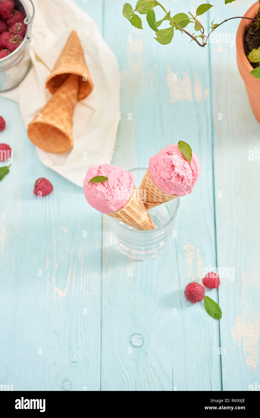 Homemade raspberry ice cream in waffle cones on rustic wooden ...