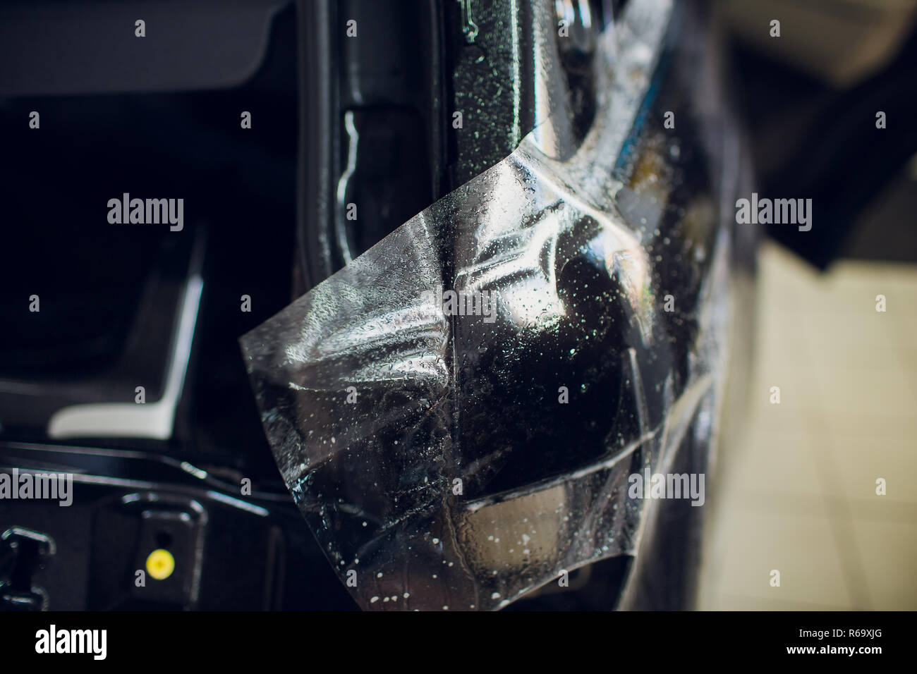 Worker hands installs car paint protection film wrap Stock Photo - Alamy