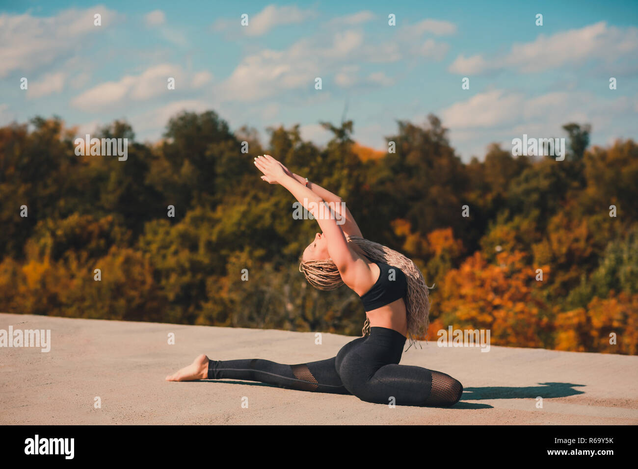 Woman doing yoga on the roof of a skyscraper in big city Stock Photo ...