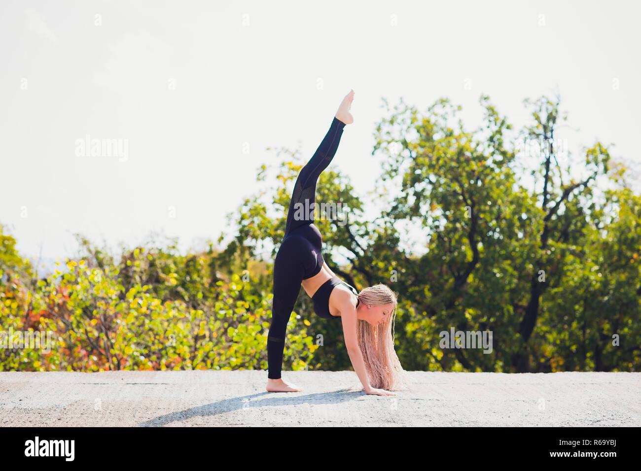 Woman doing yoga on the roof of a skyscraper in big city Stock Photo ...