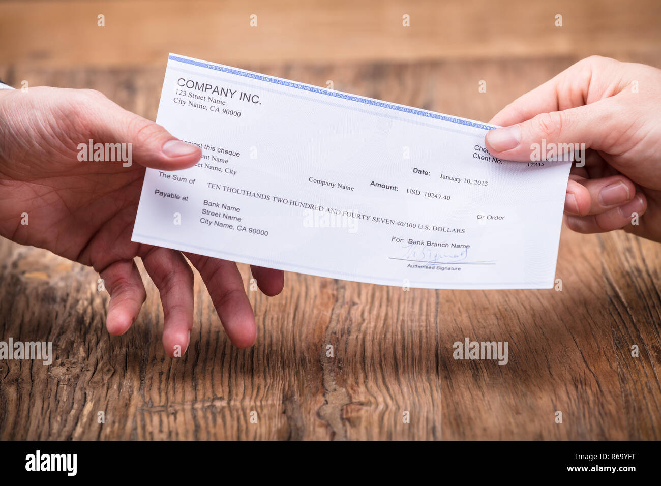 Businessperson's Hand Giving Cheque To Partner Stock Photo - Alamy