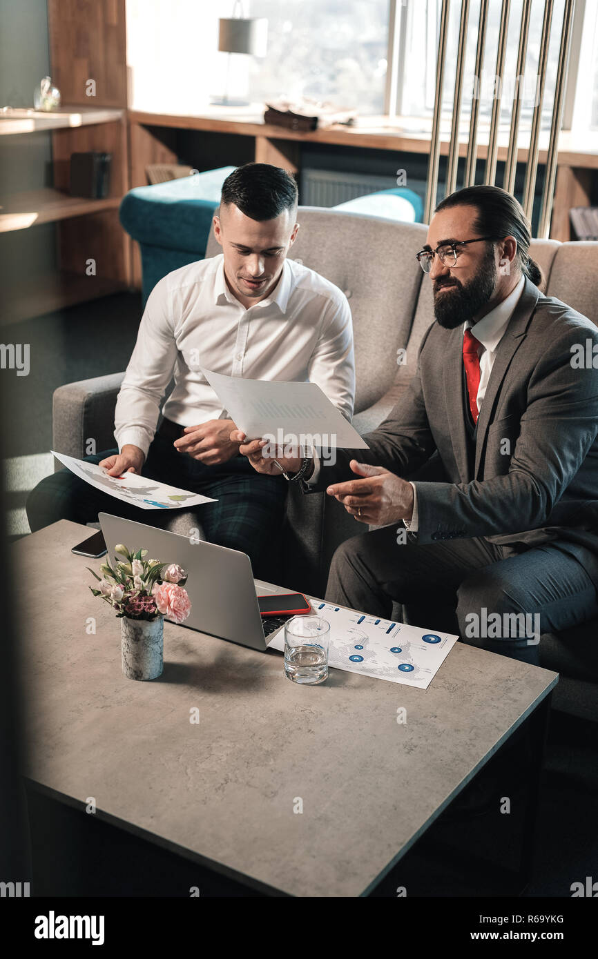 Two prosperous business partners signing contract after meeting Stock ...