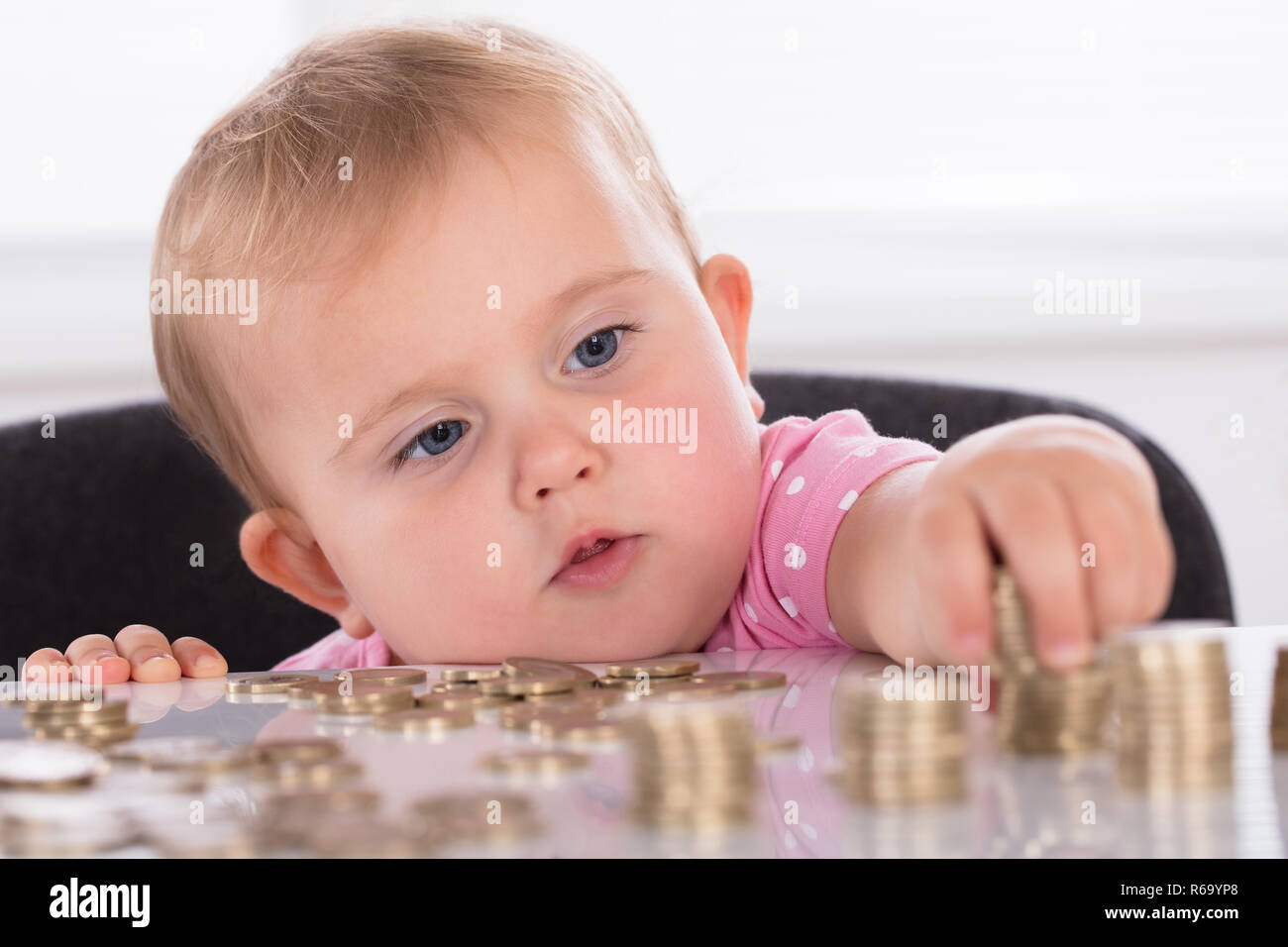 Baby Stacking Coins On Desk Stock Photo - Alamy