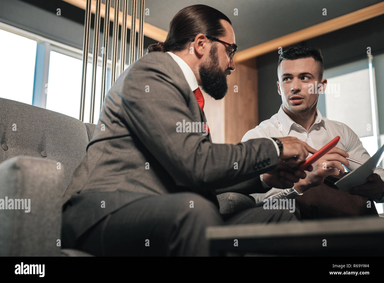 Boss wearing suit giving some instructions to his employee Stock Photo ...