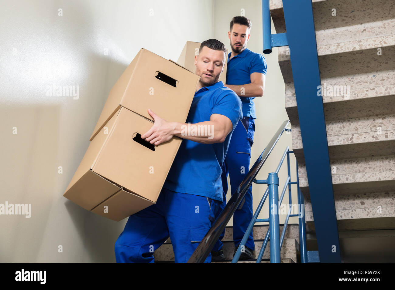 Two Movers Carrying Cardboard Boxes On Staircase Stock Photo - Alamy