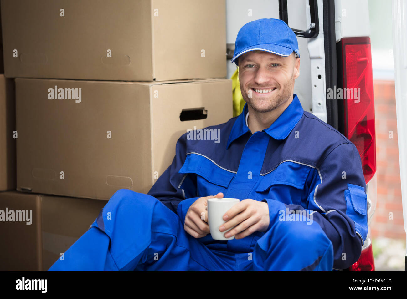 Delivery Man Drinking Cup Of Coffee Stock Photo - Alamy