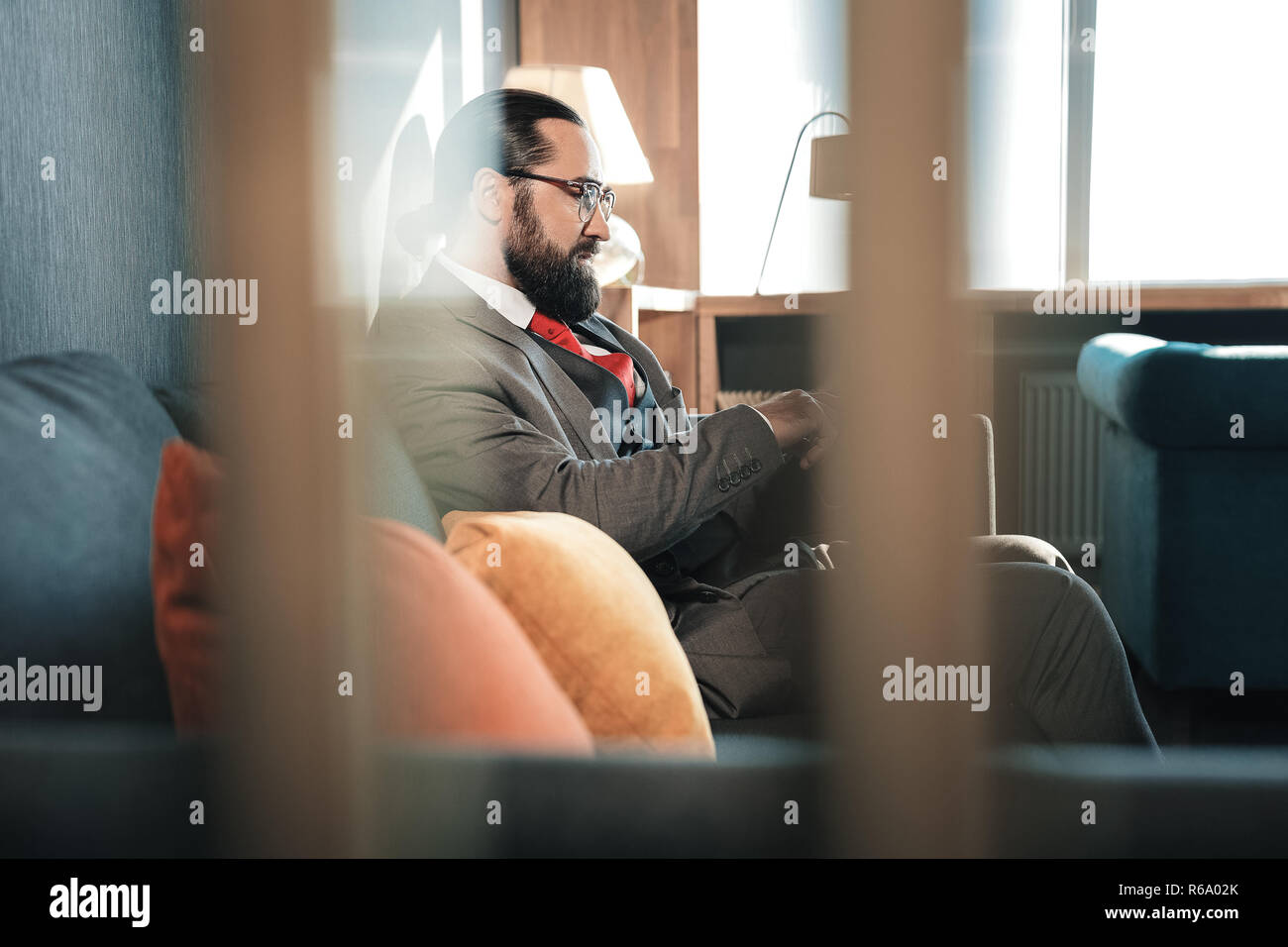 Successful prosperous man sitting in his hotel room before seminar ...