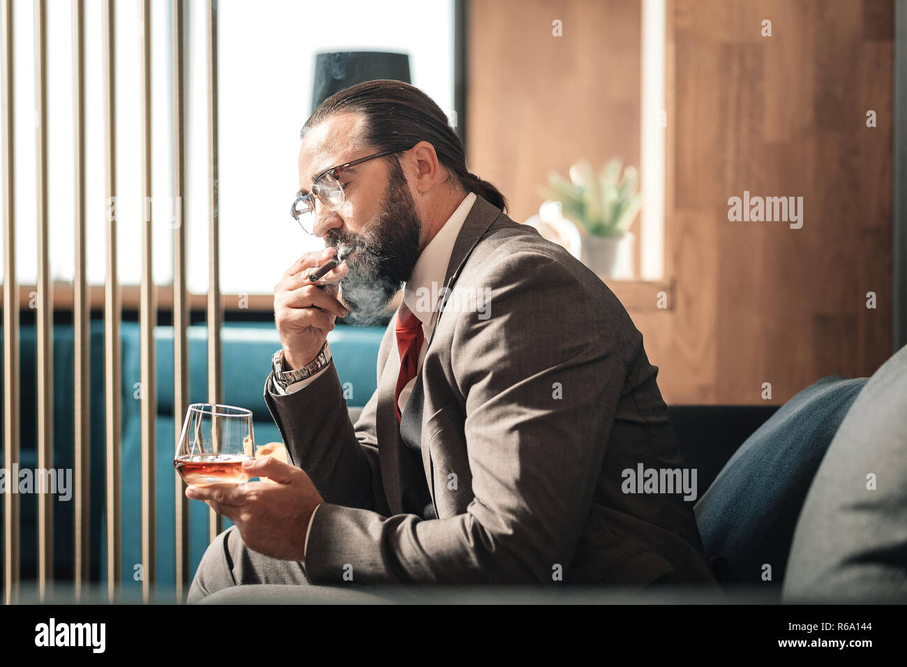 Bearded businessman smoking cigar while feeling very nervous Stock ...